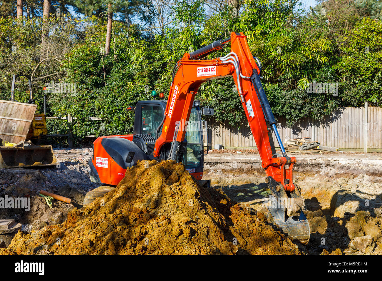 Large orange heavy plant mechanical digger parked on a construction ...
