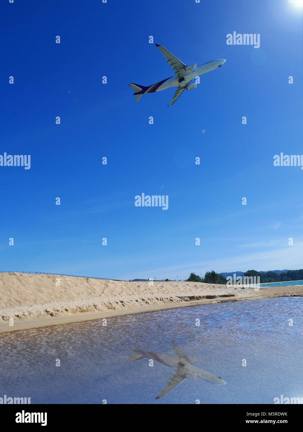 Plane taking off at the beach with reflection Stock Photo - Alamy