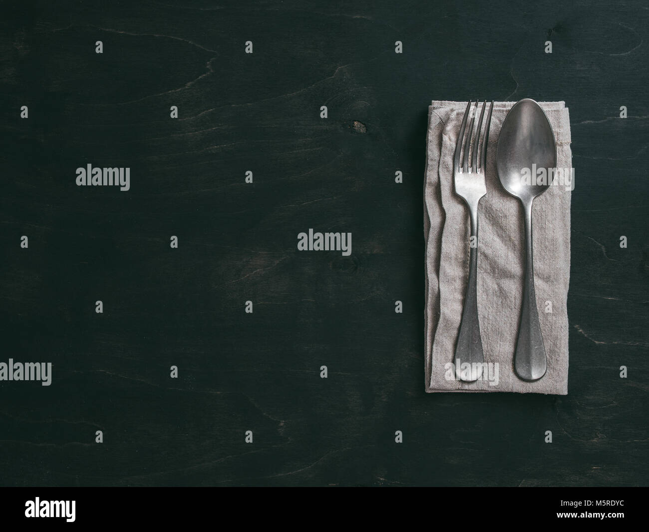 Vintage cutlery over dark background. Old tablespoon and fork on linen ...