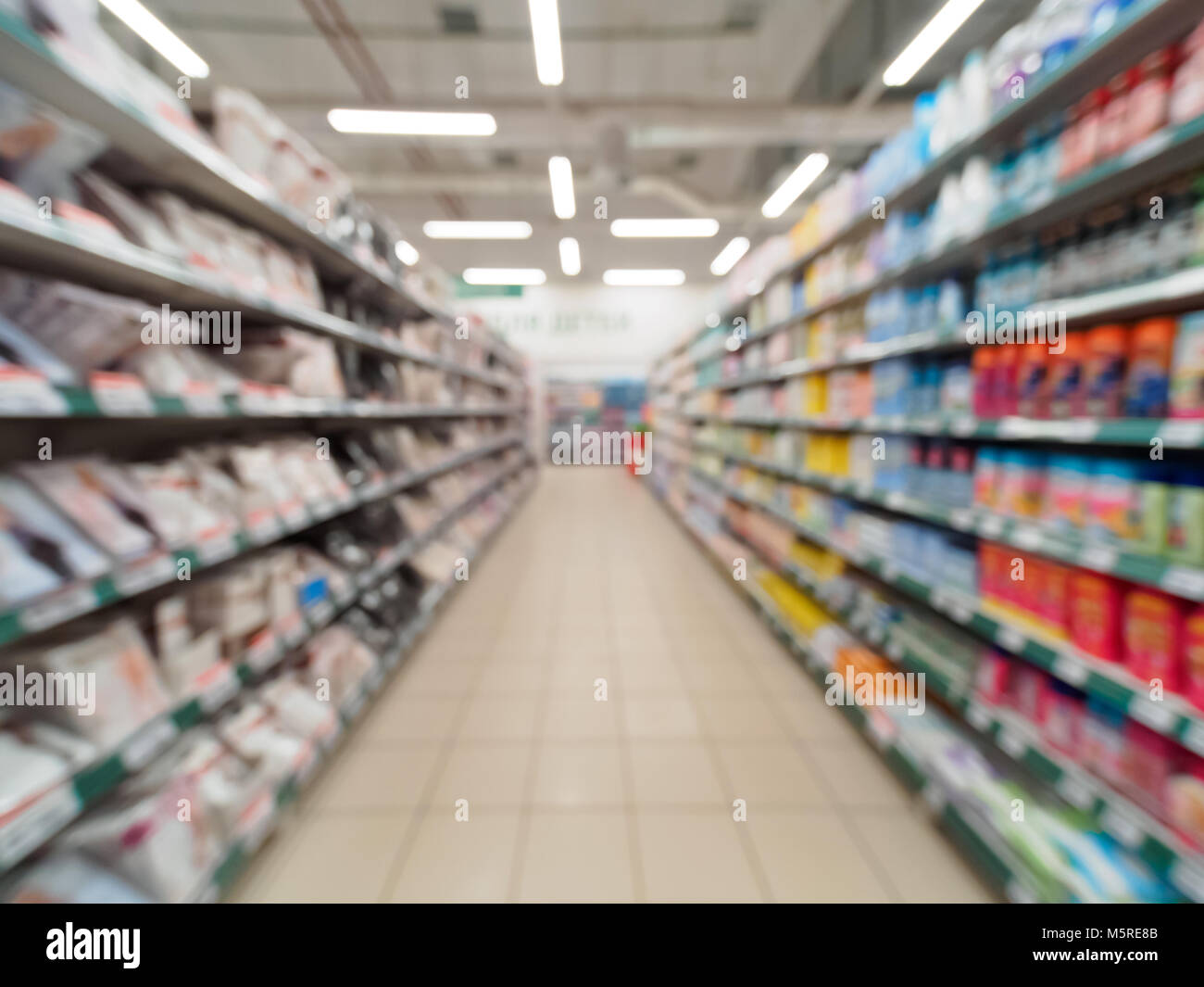 Abstract blurred supermarket aisle with colorful shelves and ...
