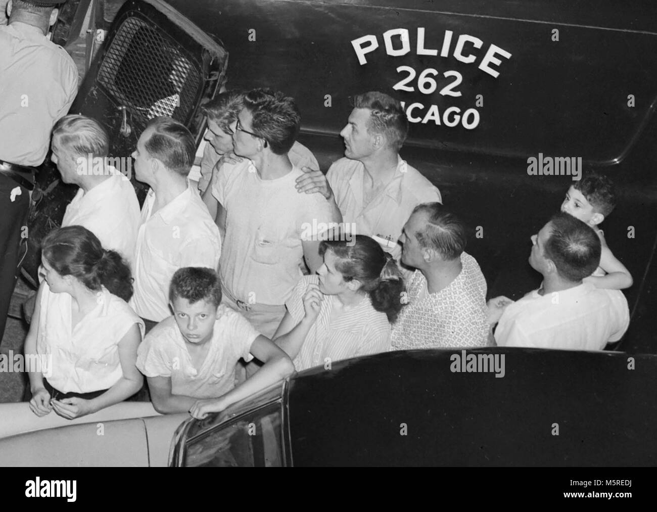 A neighborhood gathers at a crime scene in Chicago, ca. 1955 Stock ...