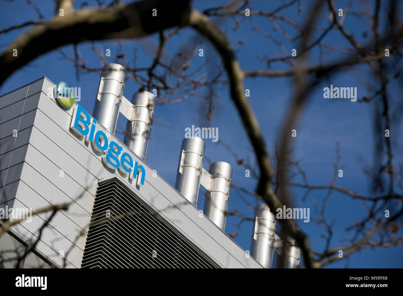 A logo sign outside of a facility occupied by Biogen, Inc., in ...