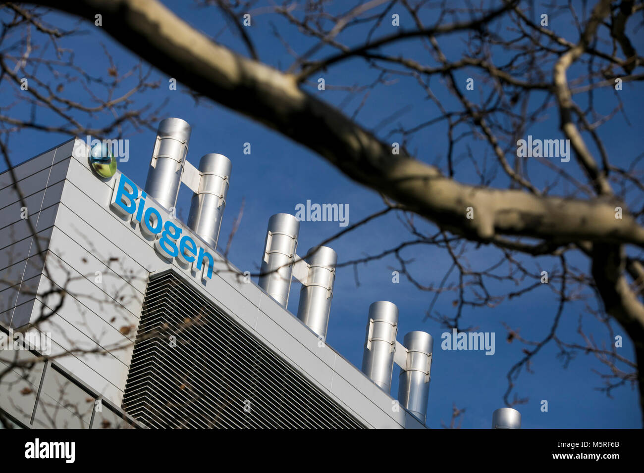 A logo sign outside of a facility occupied by Biogen, Inc., in ...