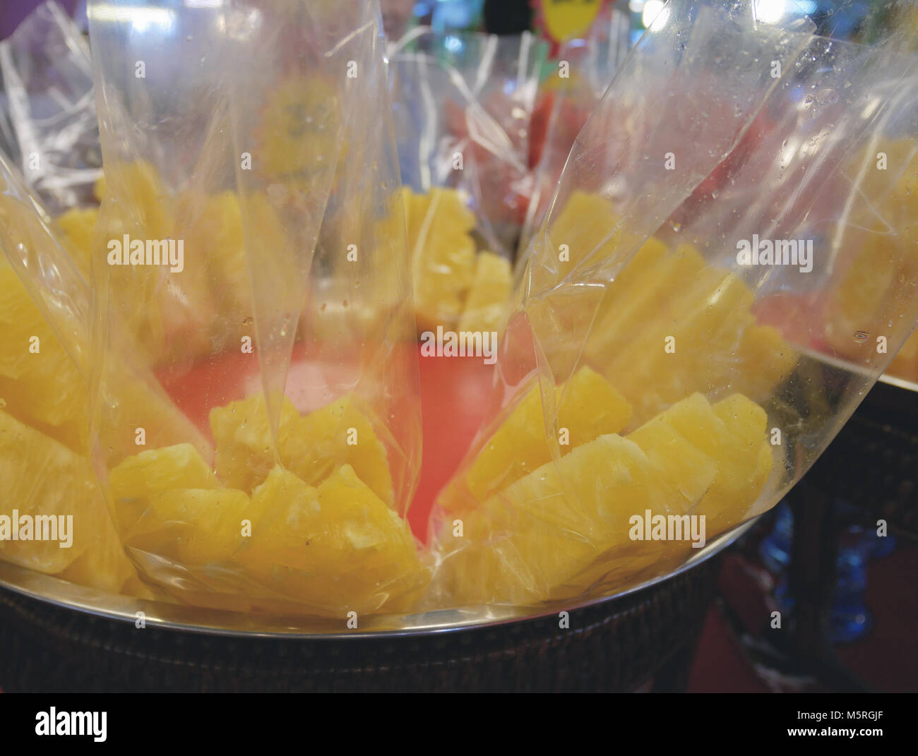 Prepared sweet ripe pineapple in plastic bags on sell Stock Photo - Alamy