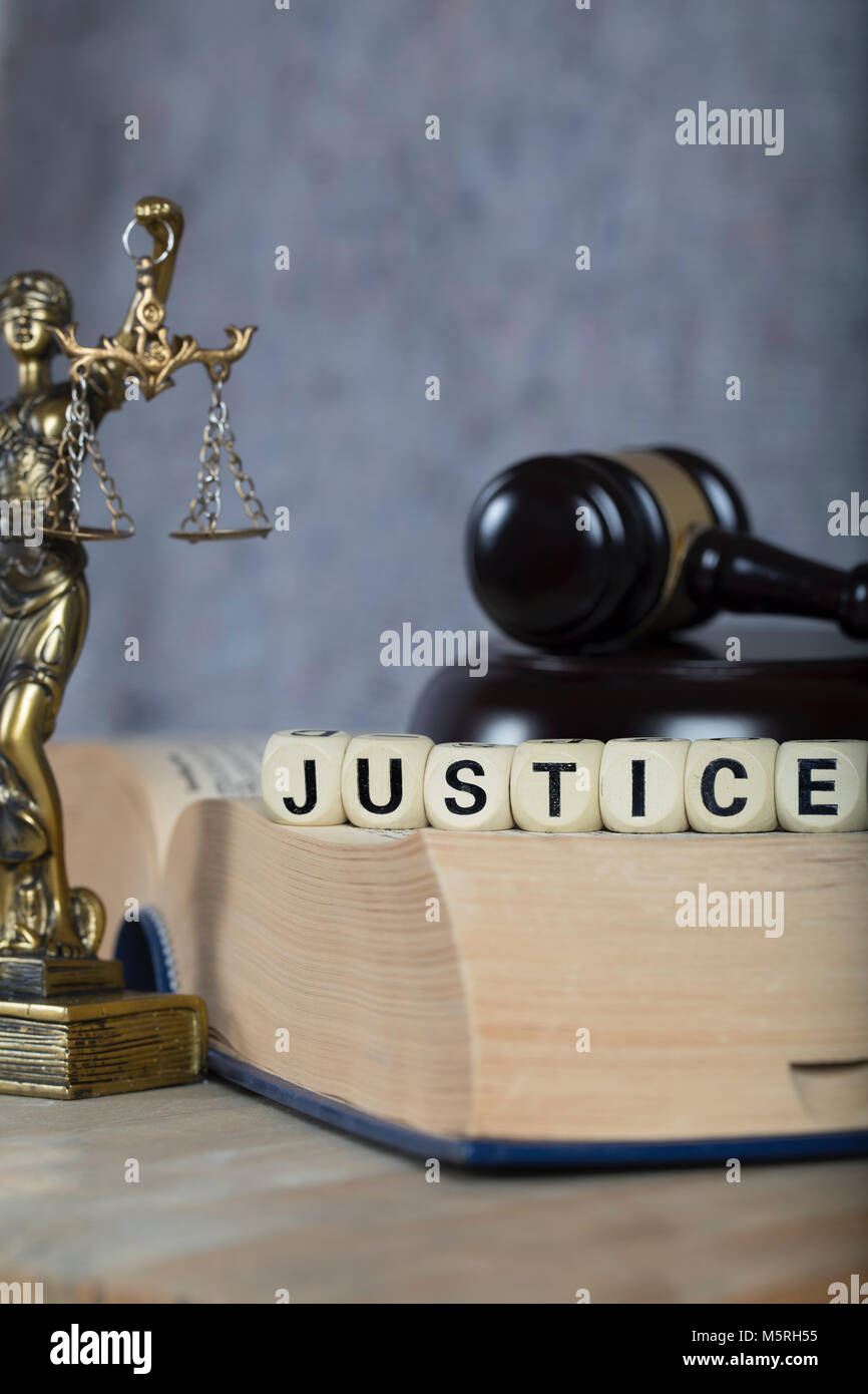 Word JUSTICE composed of wooden letters. Statue Themis and judge's ...