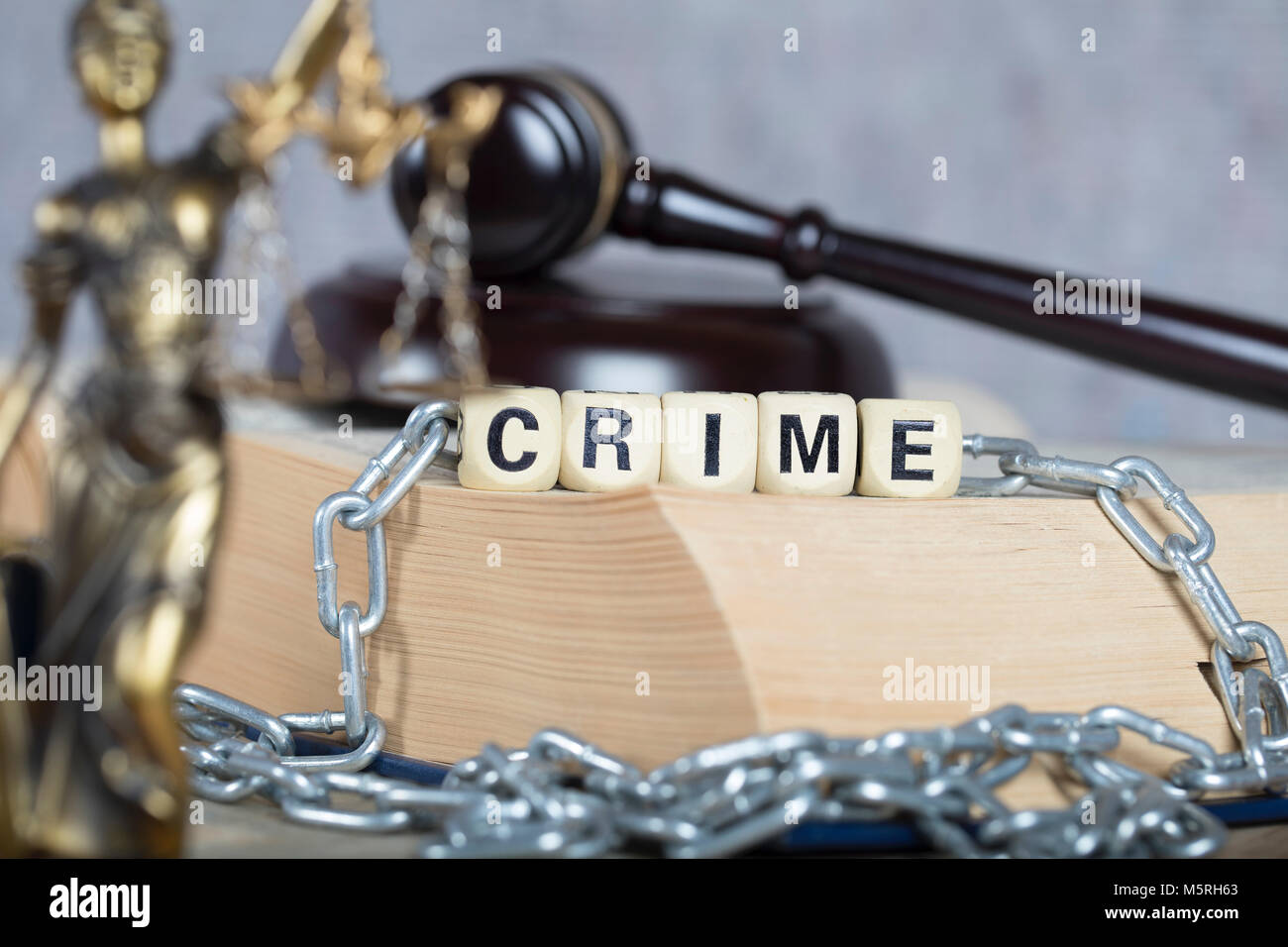 Word CRIME composed of wooden letters. Statue of Themis and judge's ...
