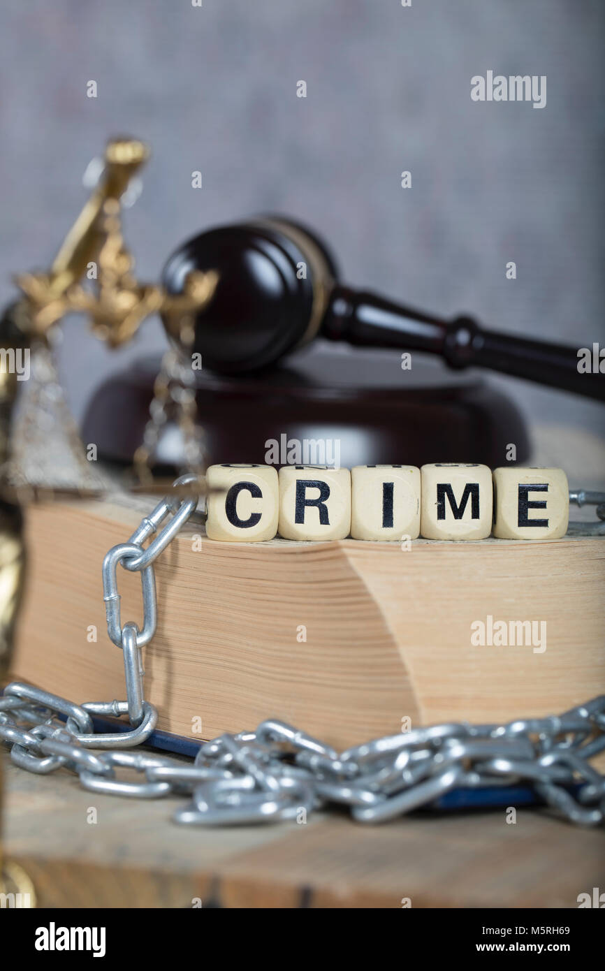 Word CRIME composed of wooden letters. Statue of Themis and judge's ...