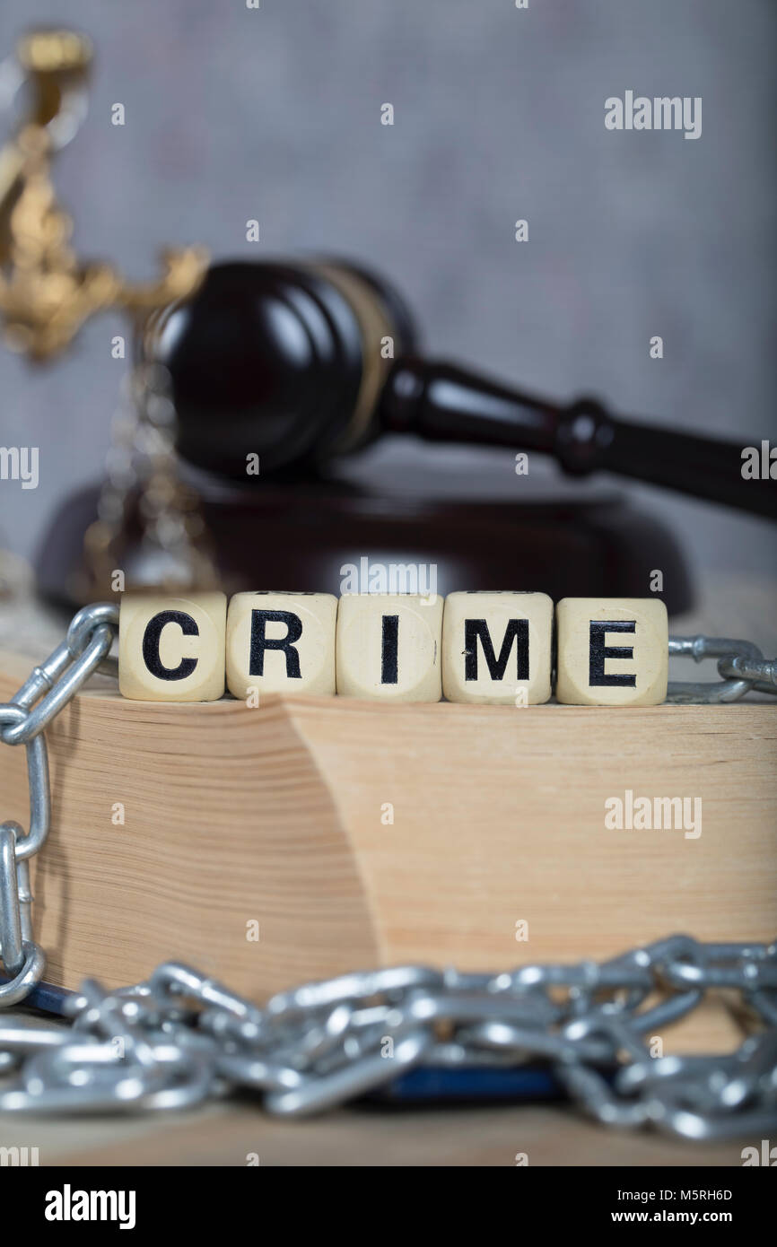 Word CRIME composed of wooden letters. Statue of Themis and judge's ...