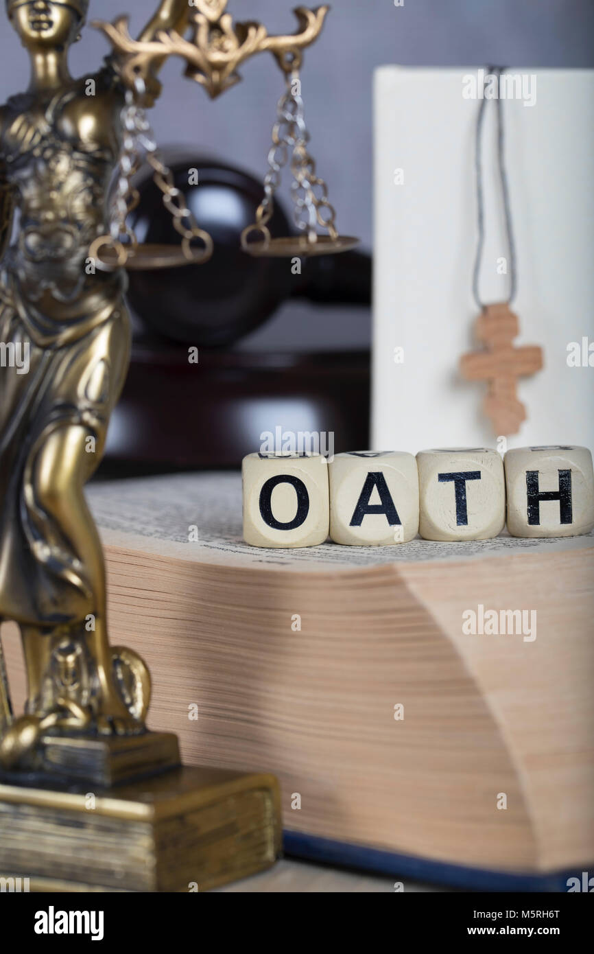Word OATH composed of wooden letters. Statue of Themis,judge's gavel ...