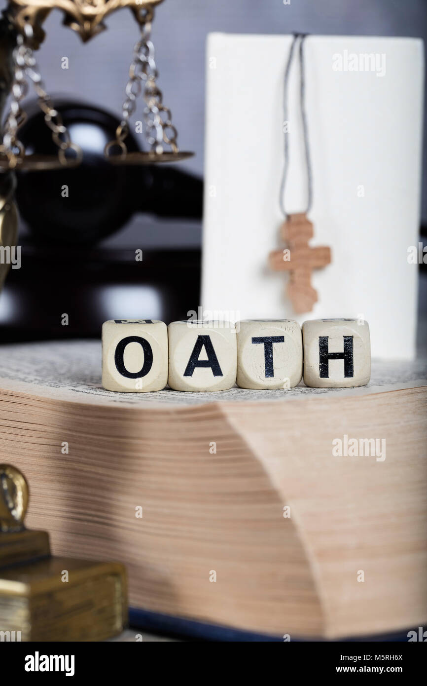 Word OATH composed of wooden letters. Statue of Themis,judge's gavel ...