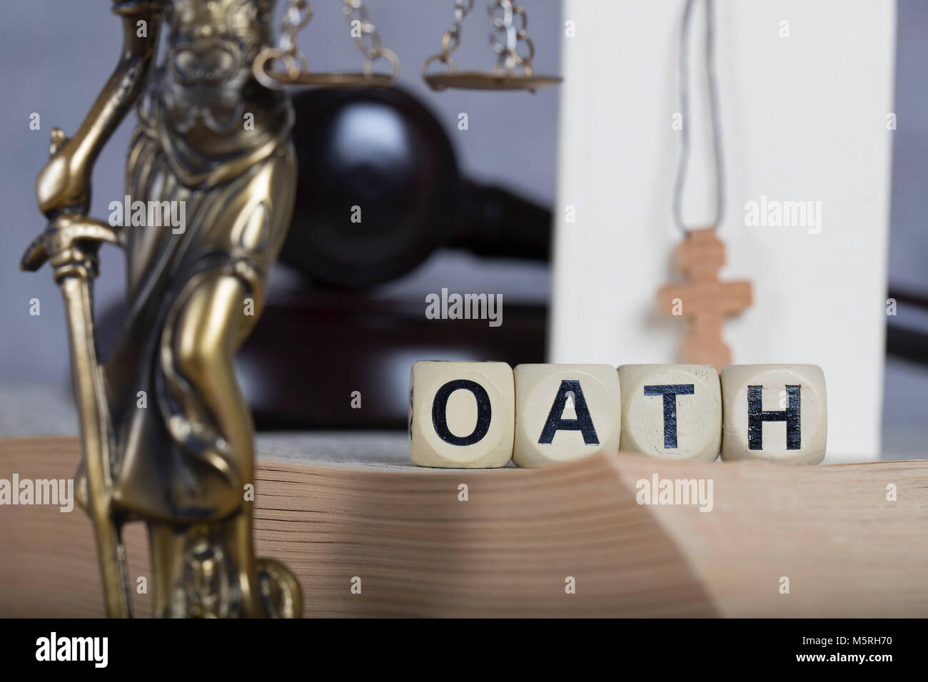 Word OATH composed of wooden letters. Statue of Themis,judge's gavel ...
