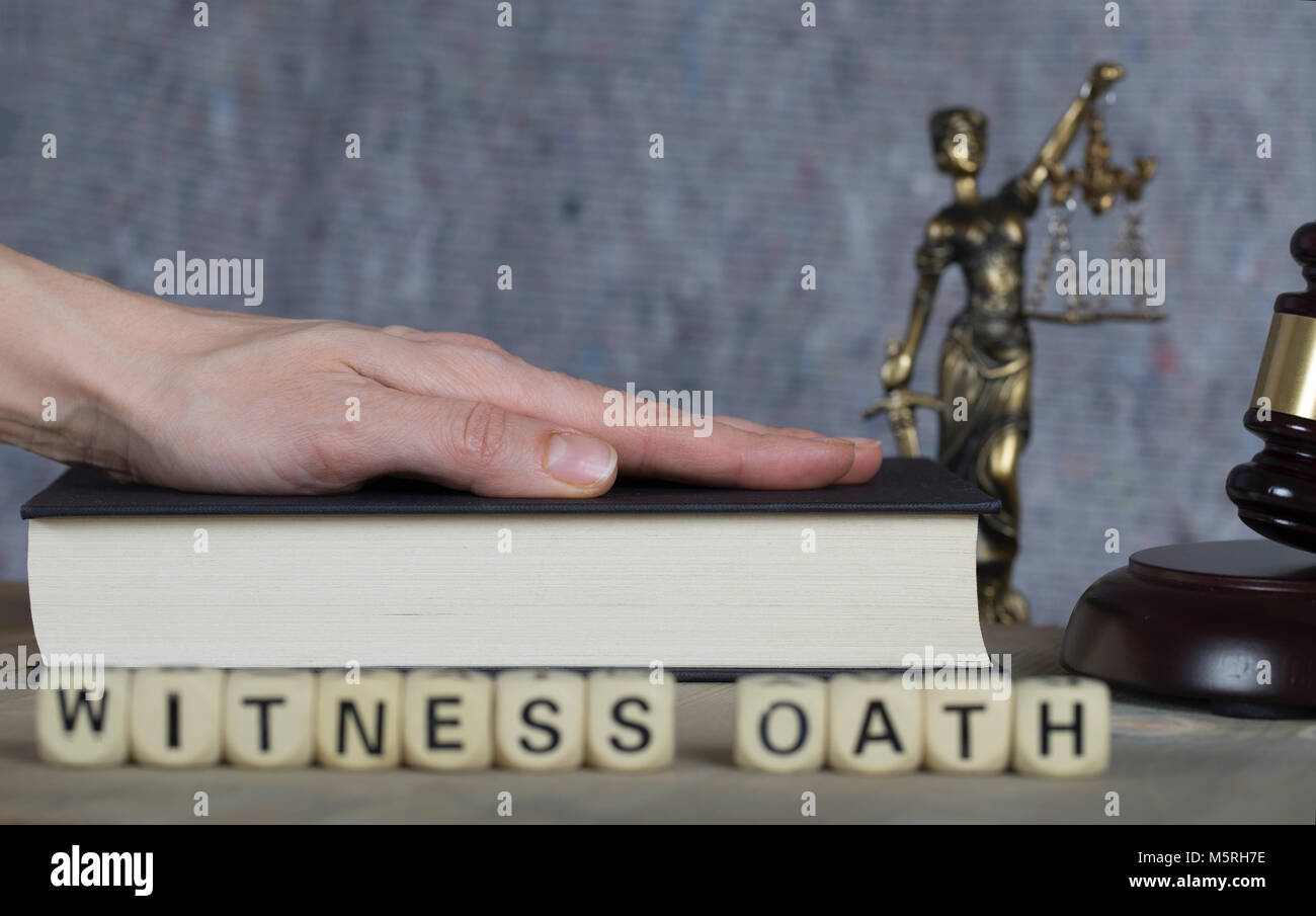 Word WITNESS OATH composed of wooden letters. Statue of Themis,judge's ...