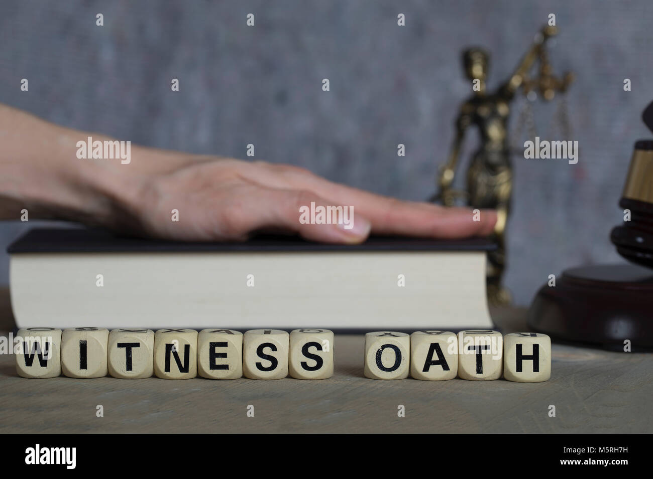 Word WITNESS OATH composed of wooden letters. Statue of Themis,judge's ...