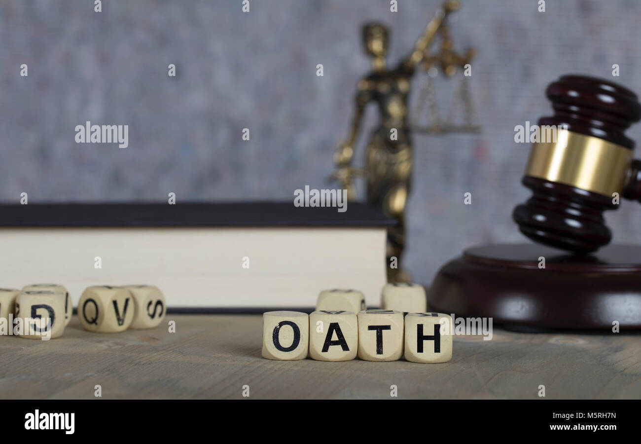 Word OATH composed of wooden letters. Statue of Themis,judge's gavel ...