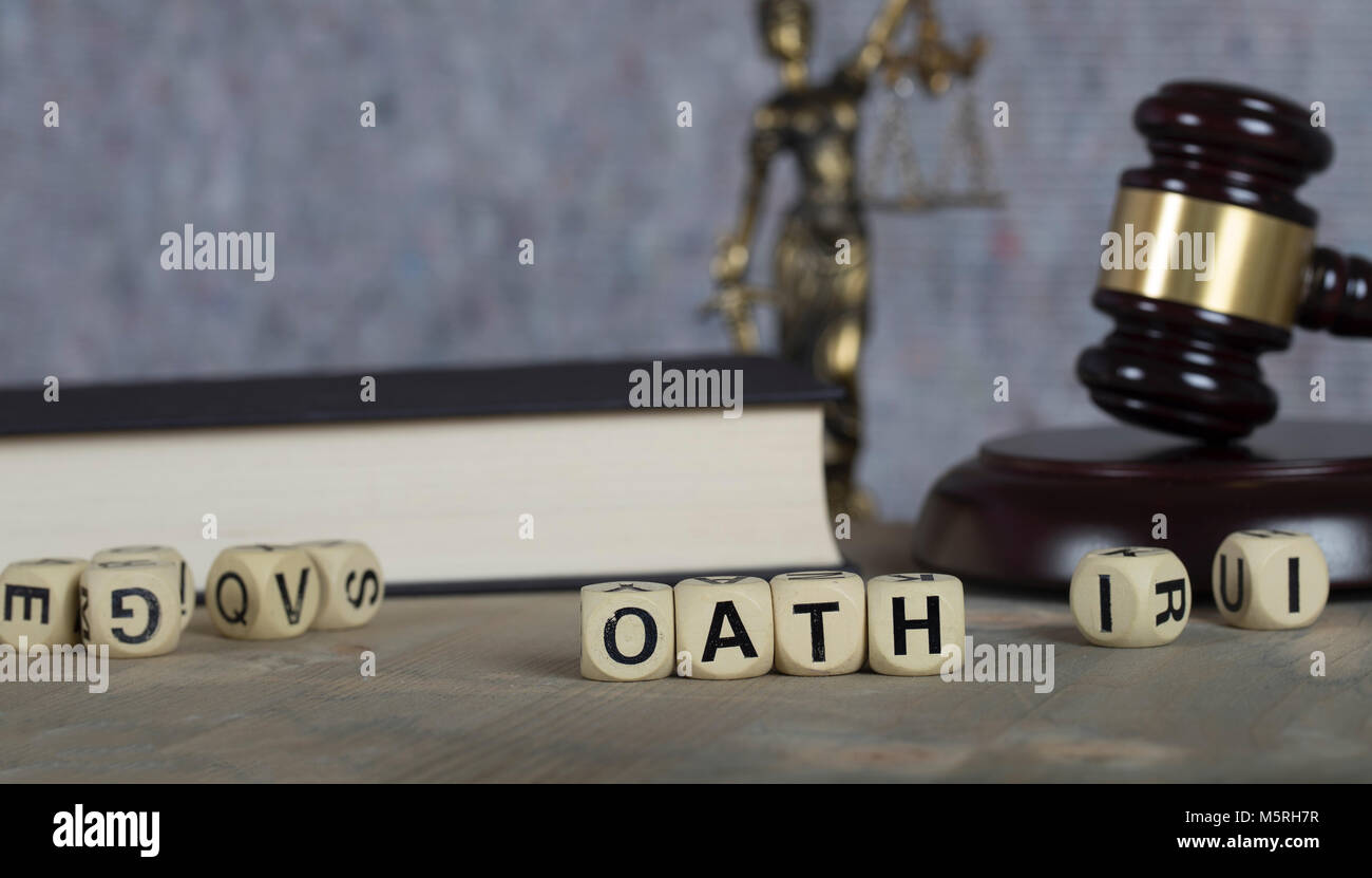 Word OATH composed of wooden letters. Statue of Themis,judge's gavel ...