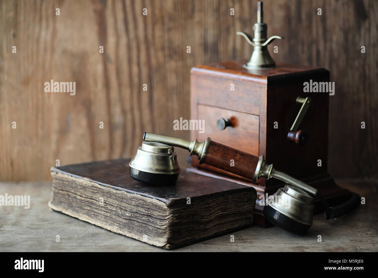 Old telephone and retro book on a wood Stock Photo - Alamy