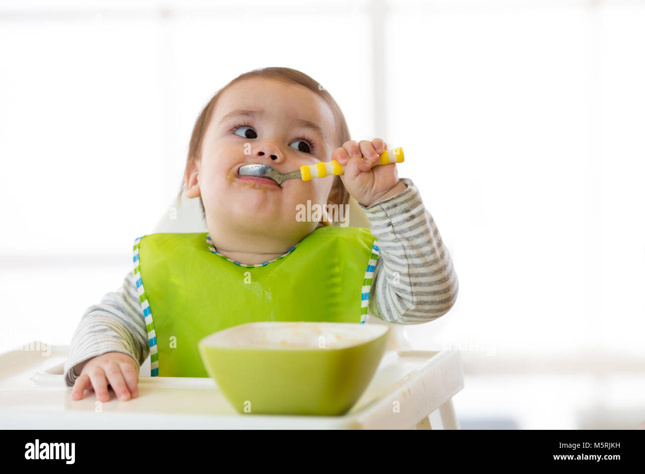 baby eating healthy food with the left hand at home Stock Photo - Alamy