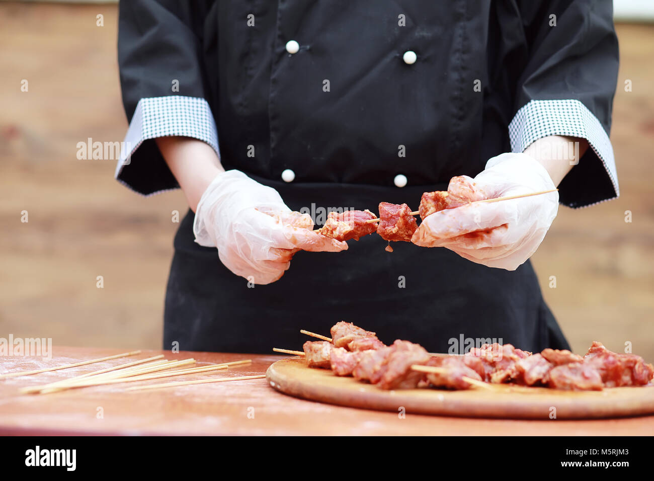 The cook cuts meat for cooking barbecue Stock Photo - Alamy