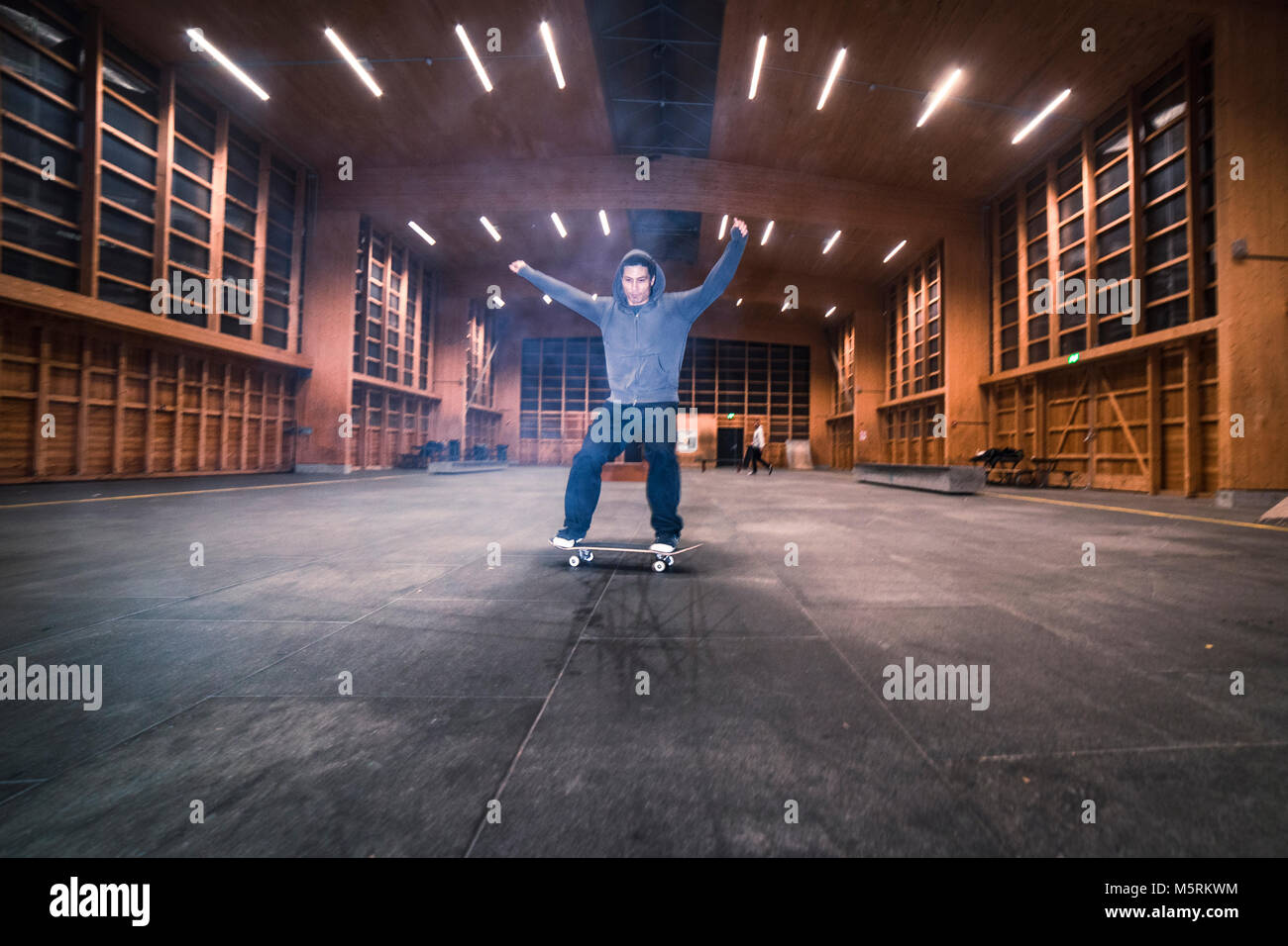 A young skater is riding his skateboard in an indoor skate hall Stock ...