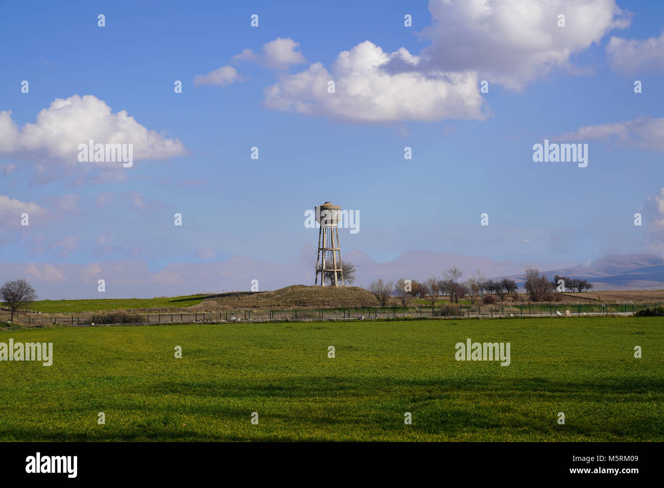 Cement water storage tank in a green grain field Stock Photo - Alamy