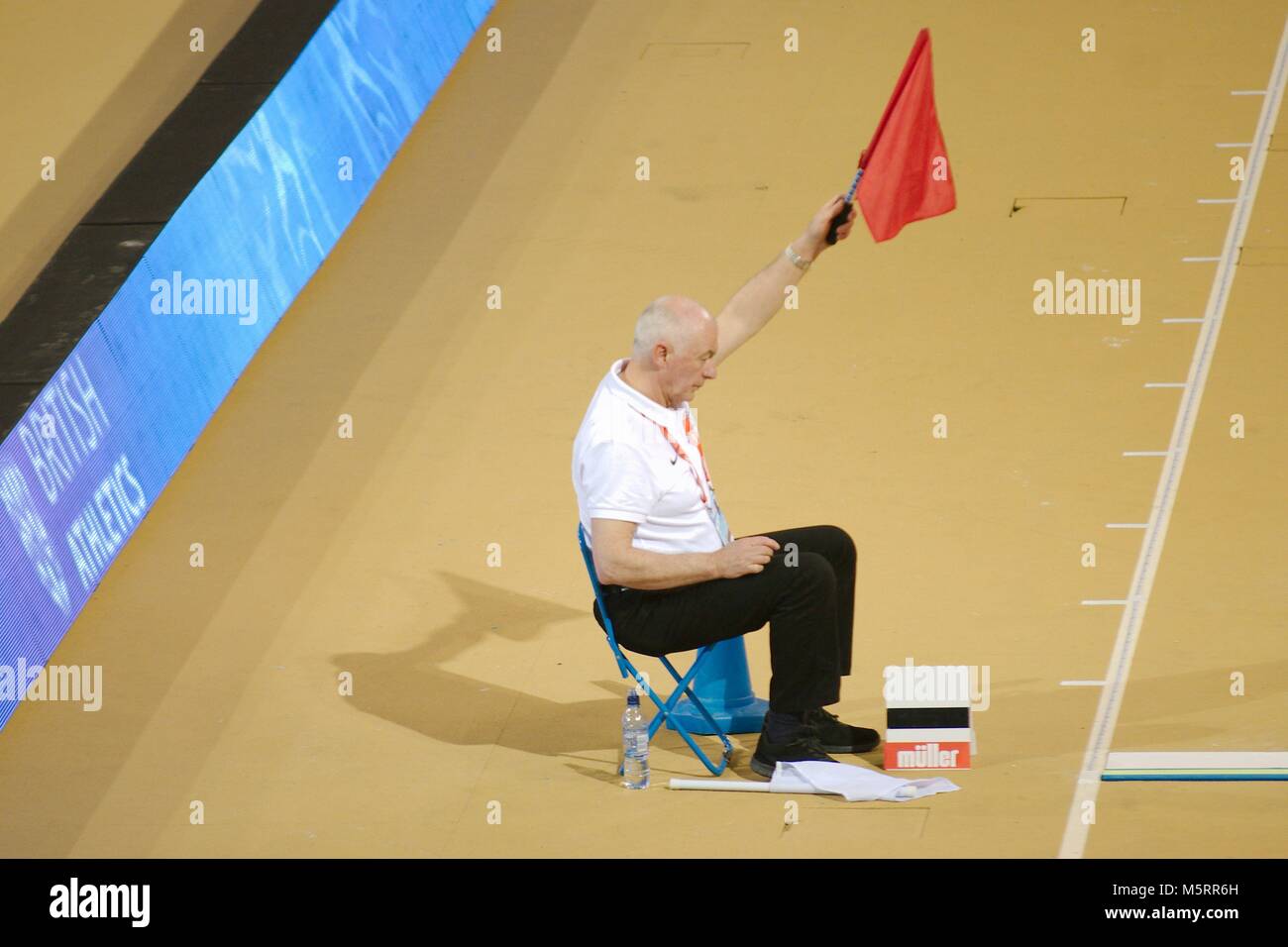 Glasgow, Scotland, 25 February 2018. An athletics official raising the ...