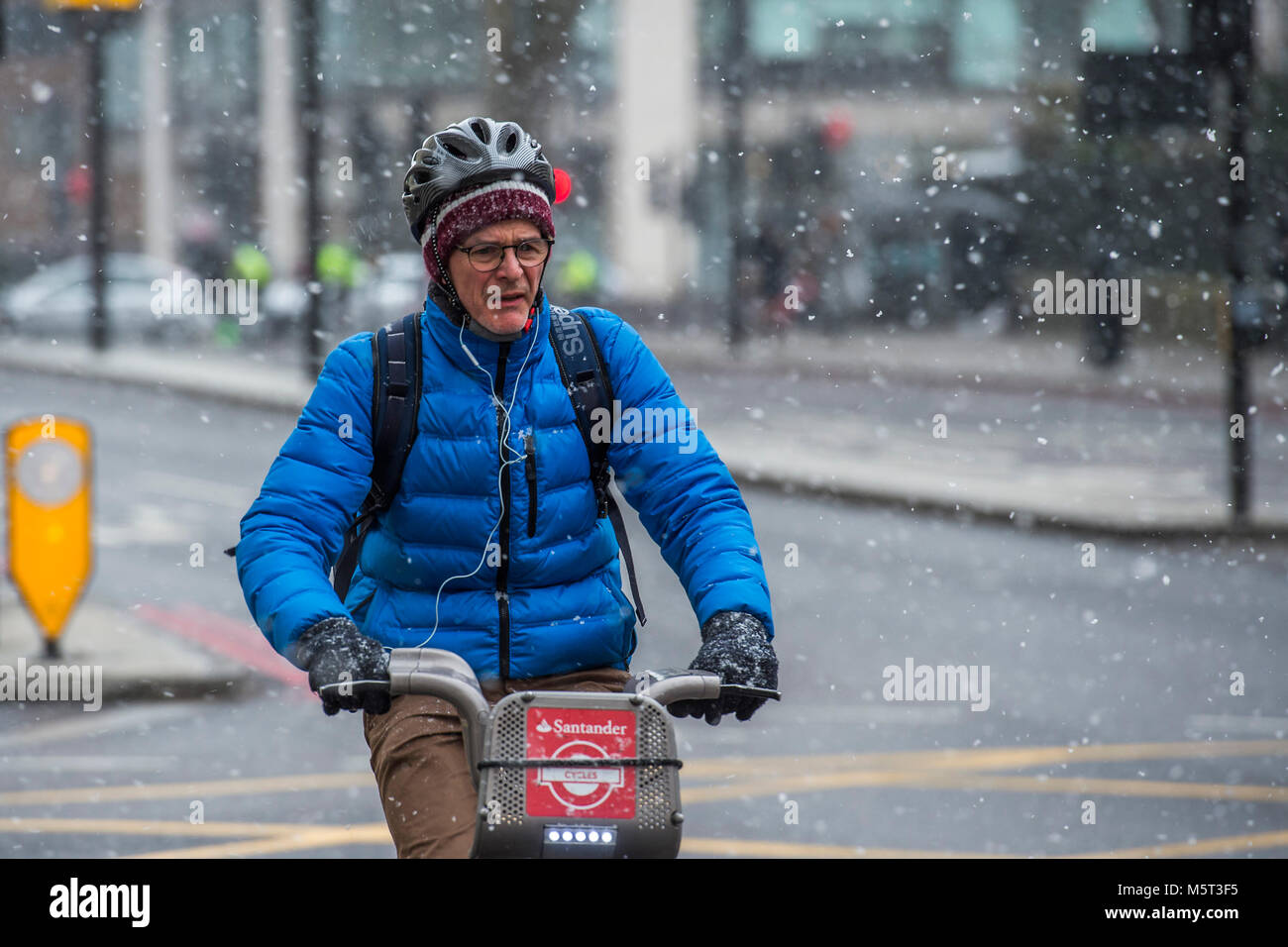 London, UK. 26th February, 2018. Cyclists struggle throught the brief ...