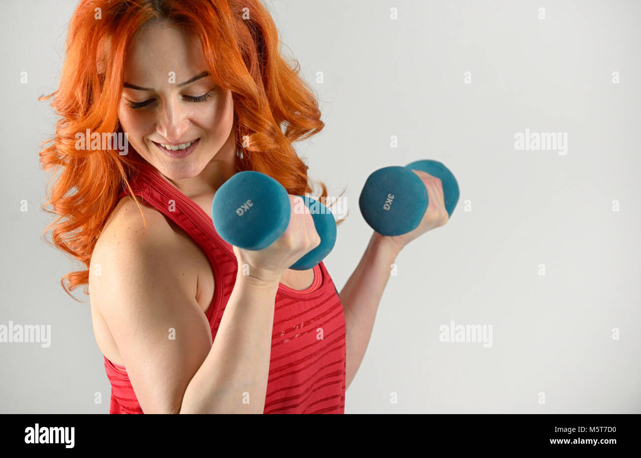 young pretty woman holding weights in studio Stock Photo - Alamy