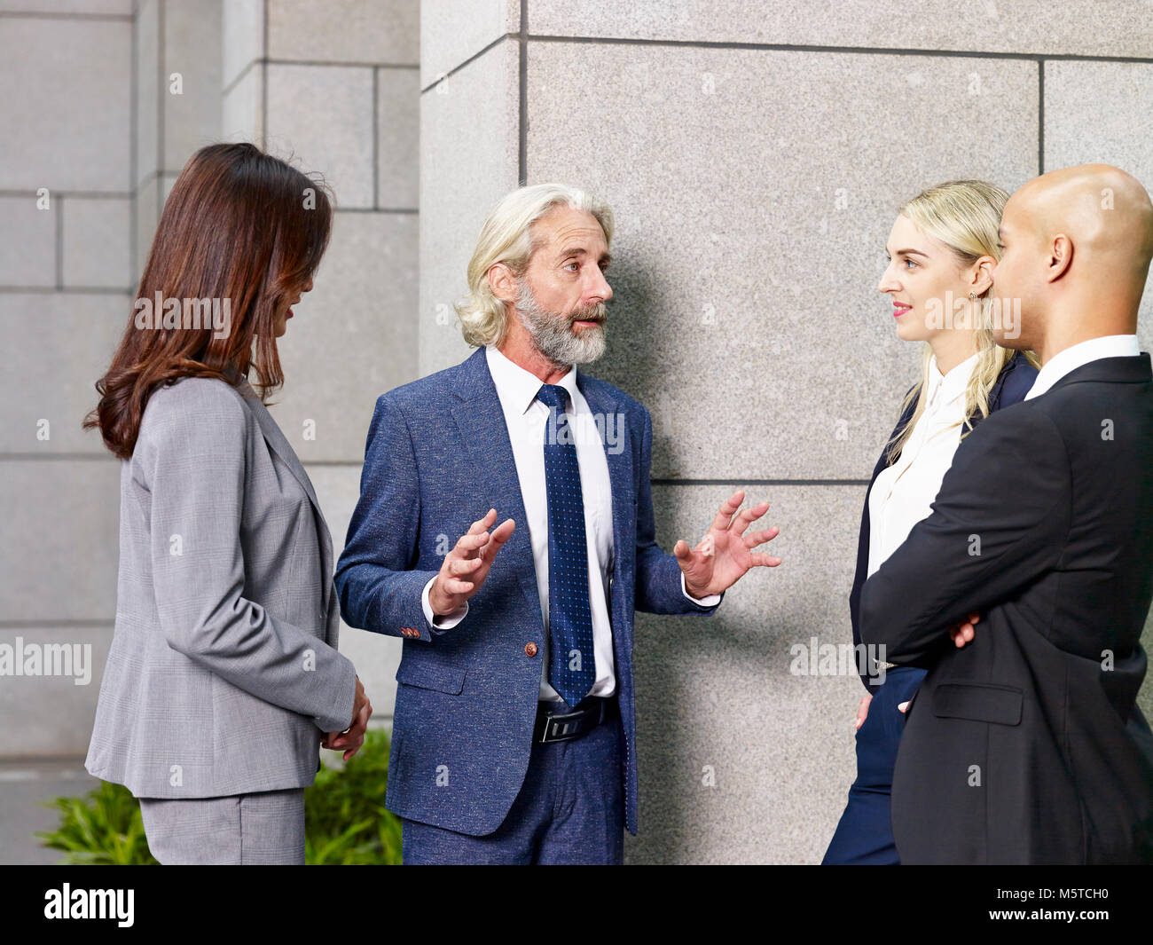 multinational and multiethnic business people standing talking chatting ...