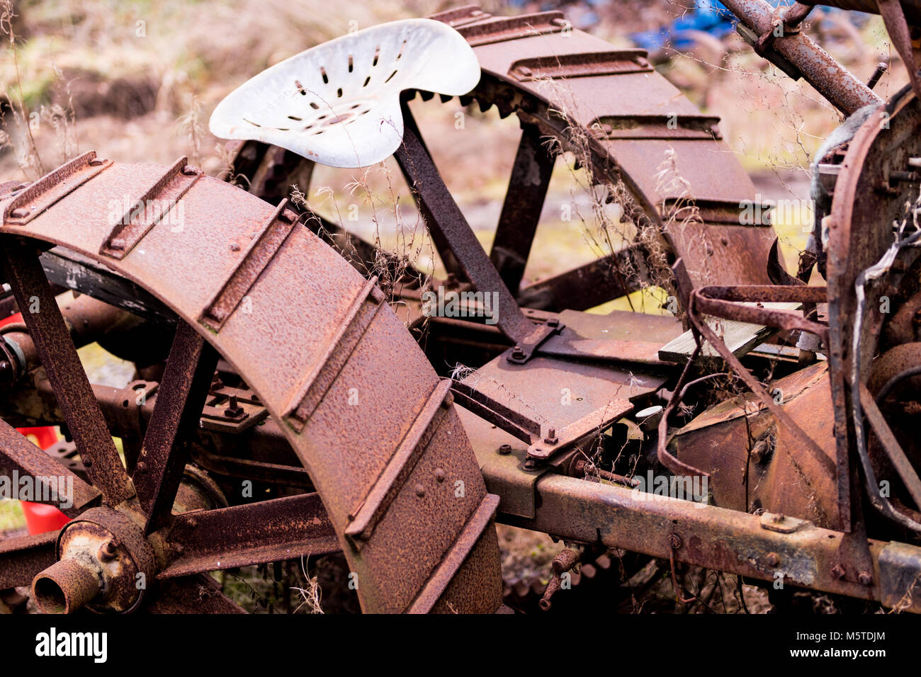 Rusty steel tractor wheels and seat cropped Stock Photo - Alamy