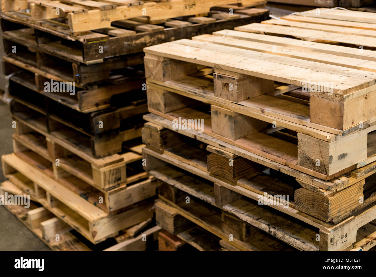 Used and new pallets stacked in rows cropped Stock Photo - Alamy
