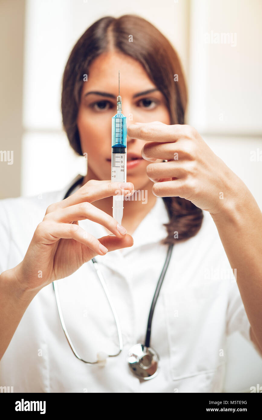 Young female nurse standing in her consulting room and preparing an ...