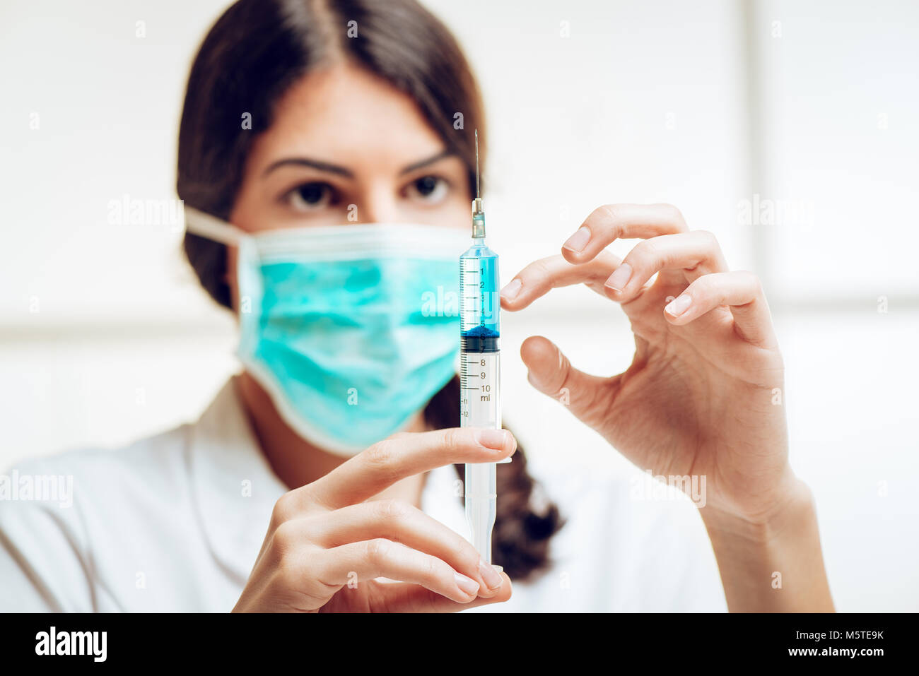 Young female nurse standing in her consulting room and preparing an ...