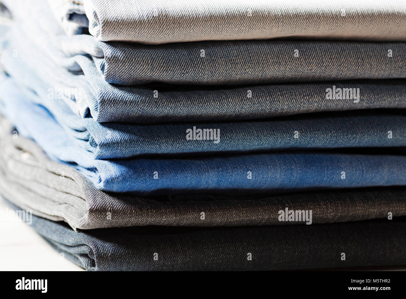 Stack of jeans in different colors Stock Photo - Alamy