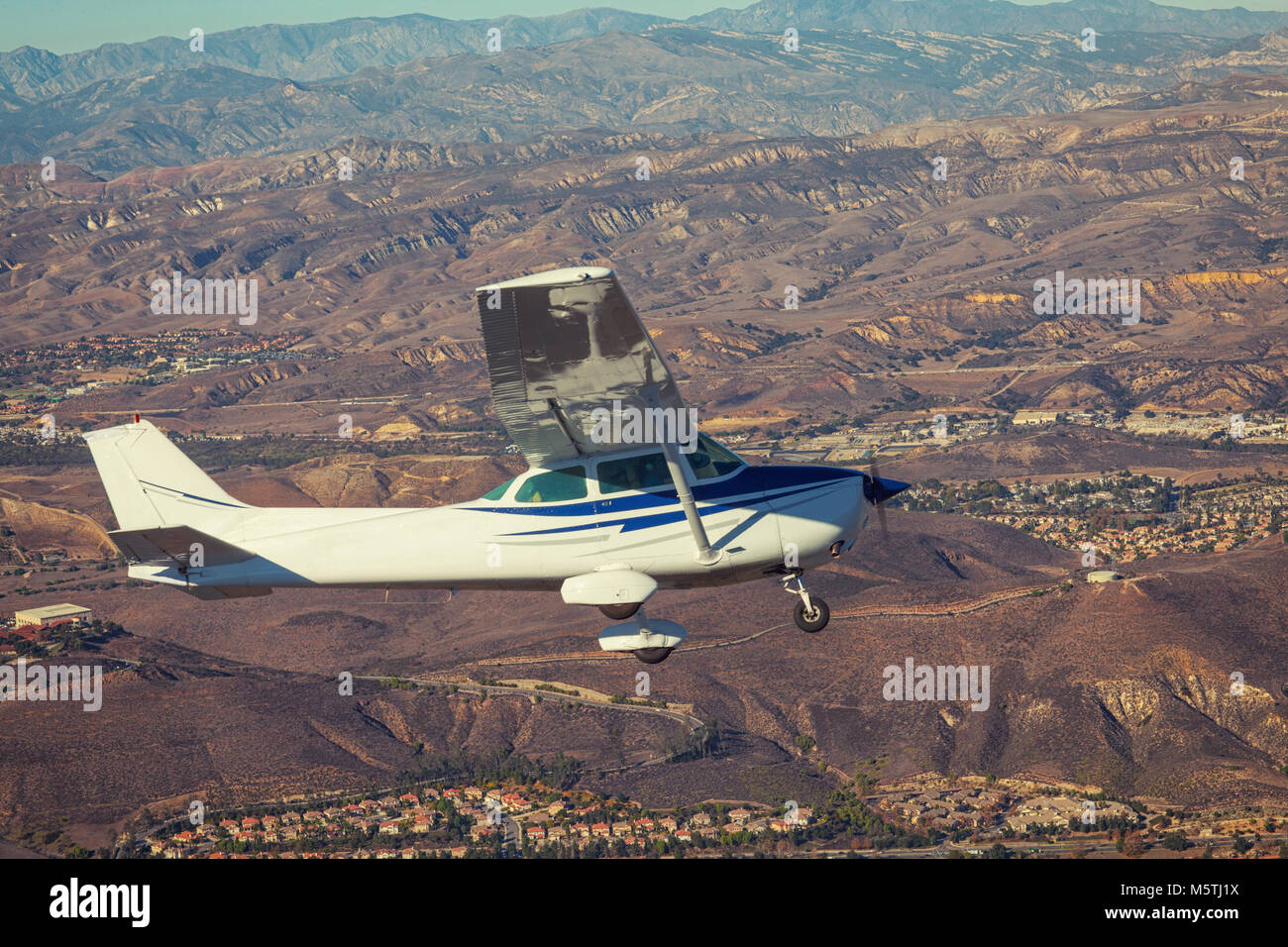 Small airplane flying in the sky over the mountains in California Stock ...