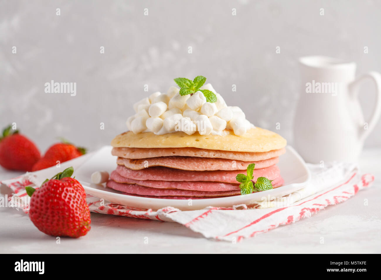 Stack of pink ombre pancakes with marshmallow. Breakfast background ...