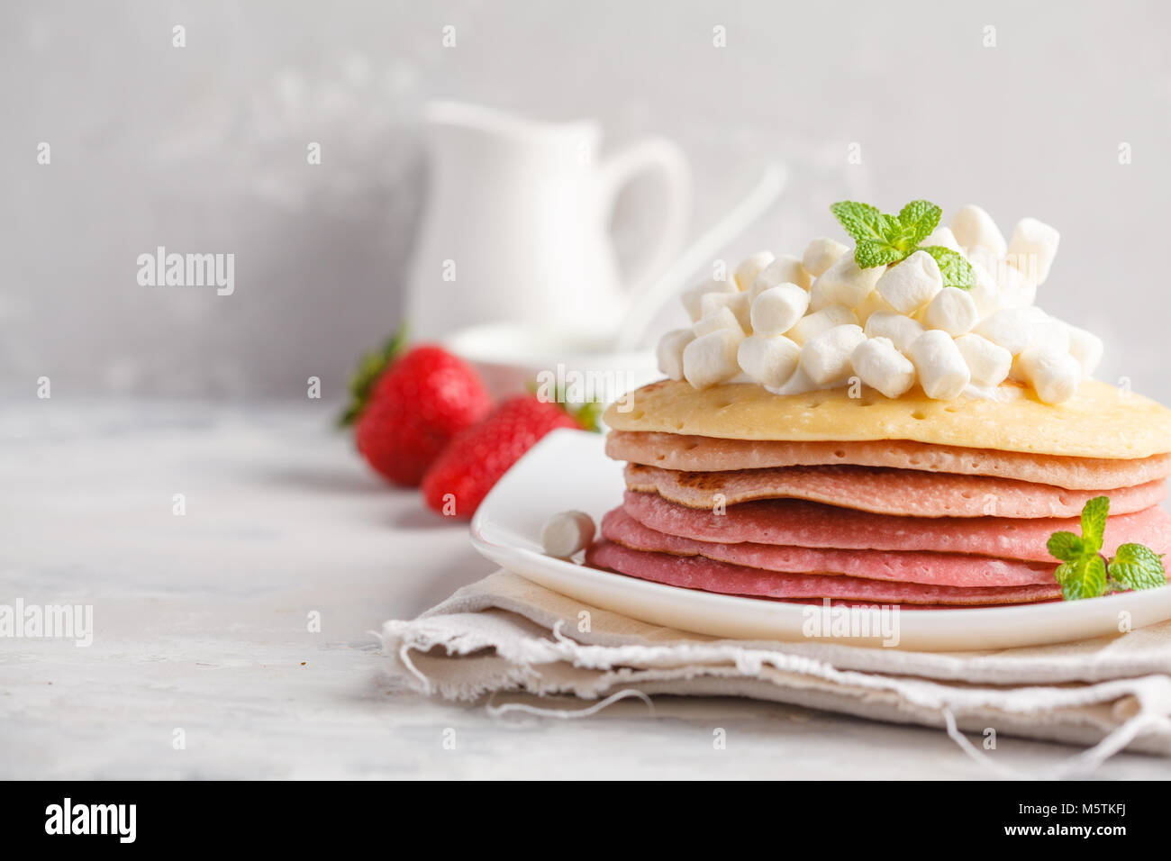 Stack of pink ombre pancakes with marshmallow. Breakfast background ...