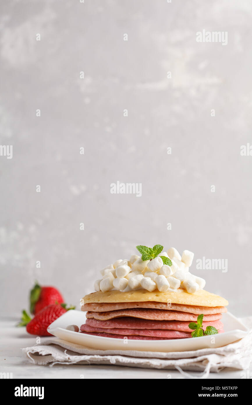 Stack of pink ombre pancakes with marshmallow. Breakfast background ...