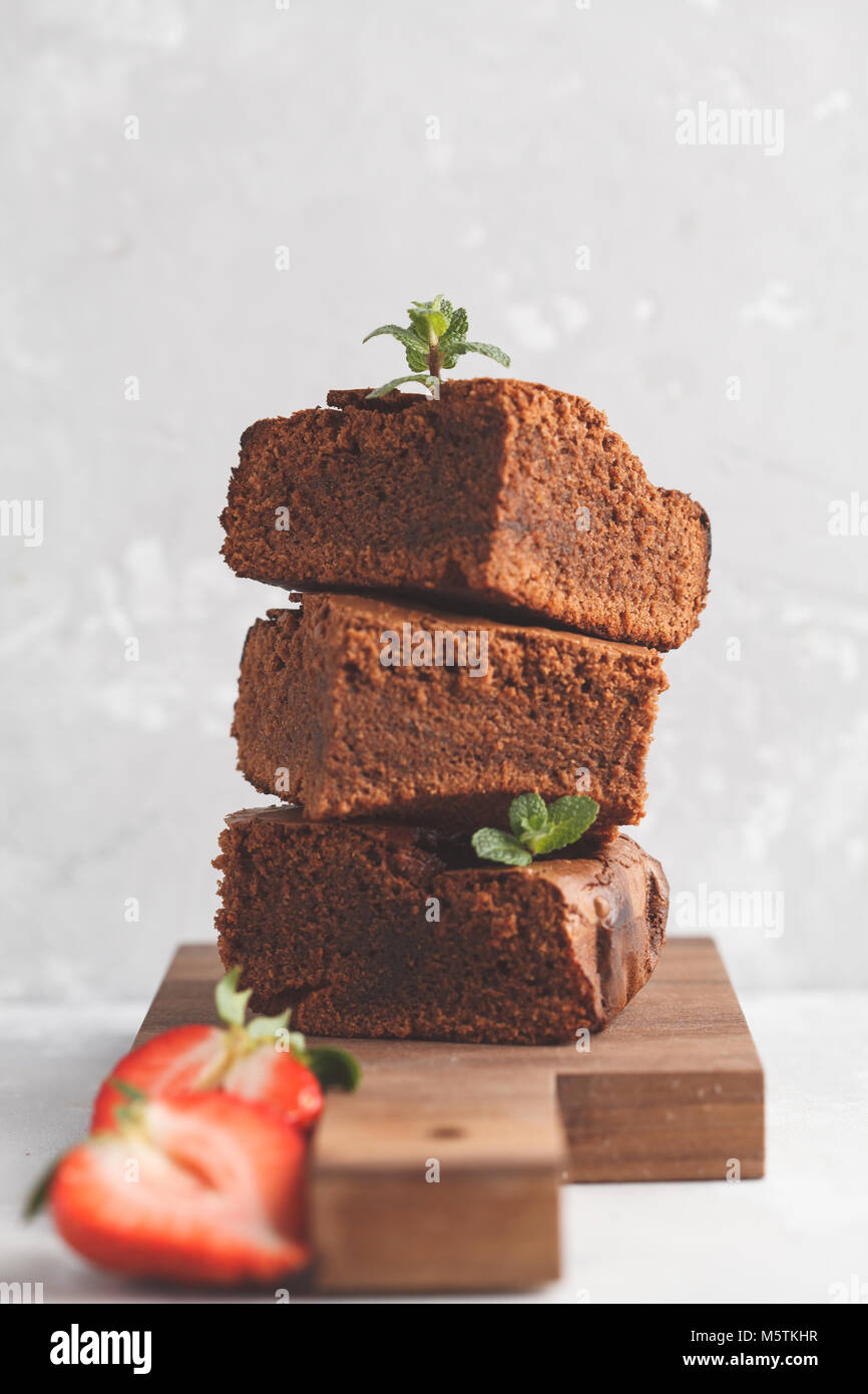 A stack of pieces of homemade dark chocolate brownie with strawberries ...