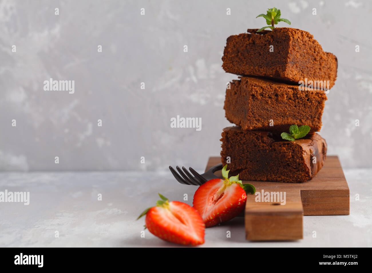 A stack of pieces of homemade dark chocolate brownie with strawberries ...