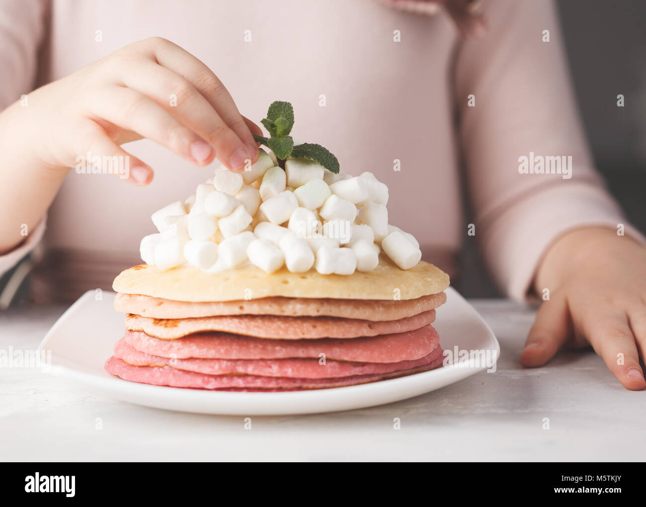 Child girl cooking and eating pink ombre pancakes with marshmallow ...