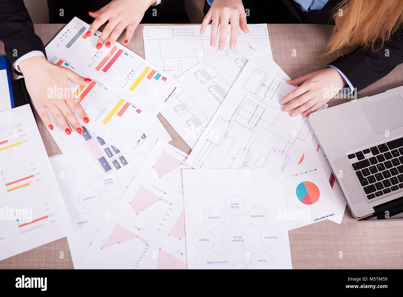 Analyzing charts and diagrams on the table Stock Photo - Alamy