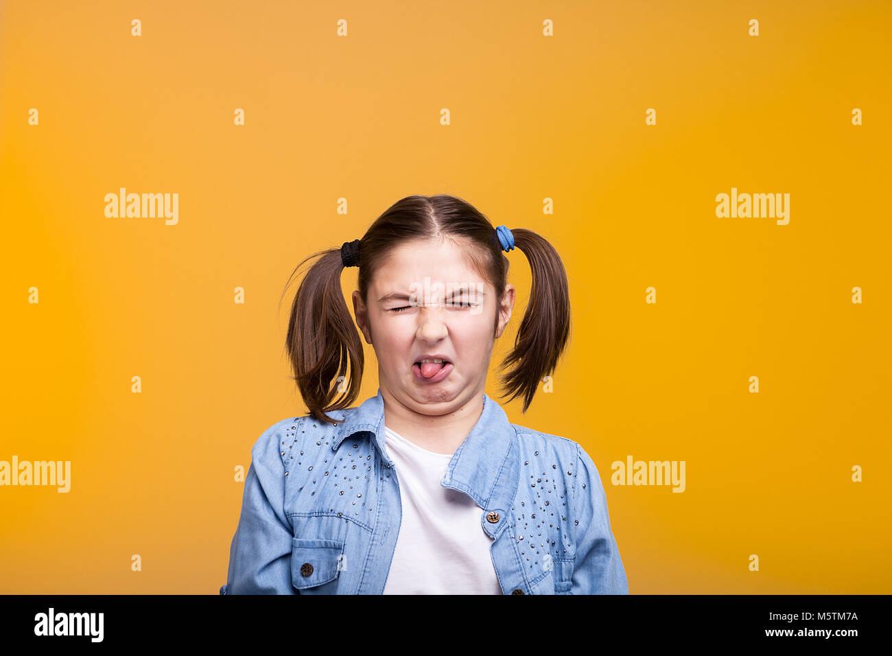 Girl in studio making a disgusted face with eyes closed Stock Photo - Alamy