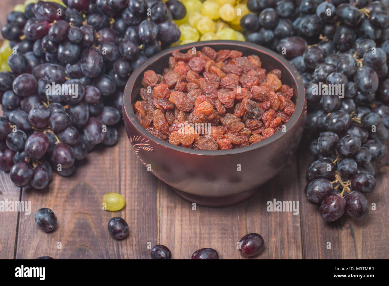 Raisins in bowl and grapes Stock Photo - Alamy