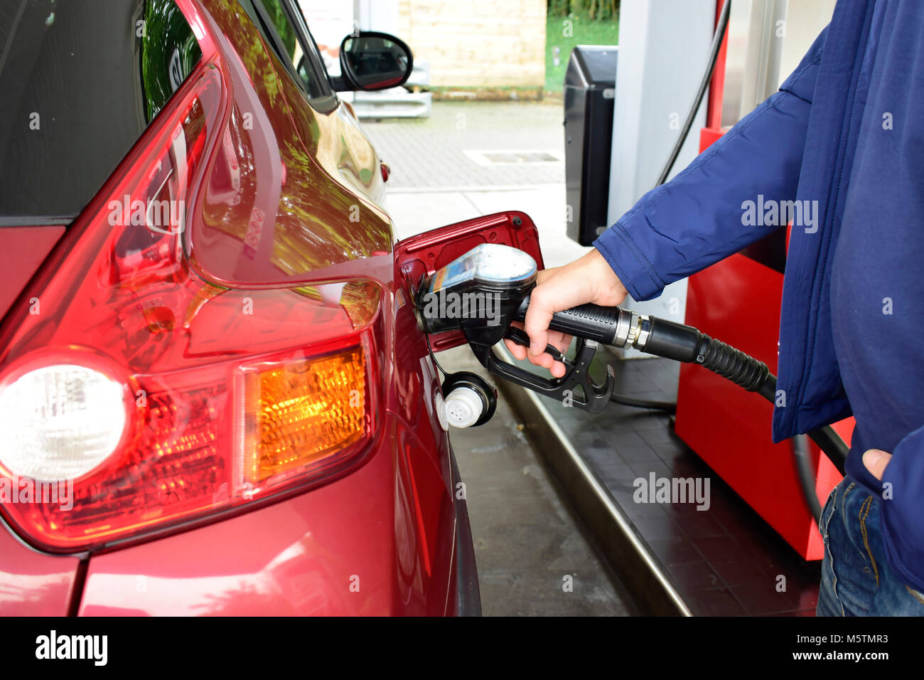 A man pumping or putting gasoline fuel in a car at gas station Stock ...