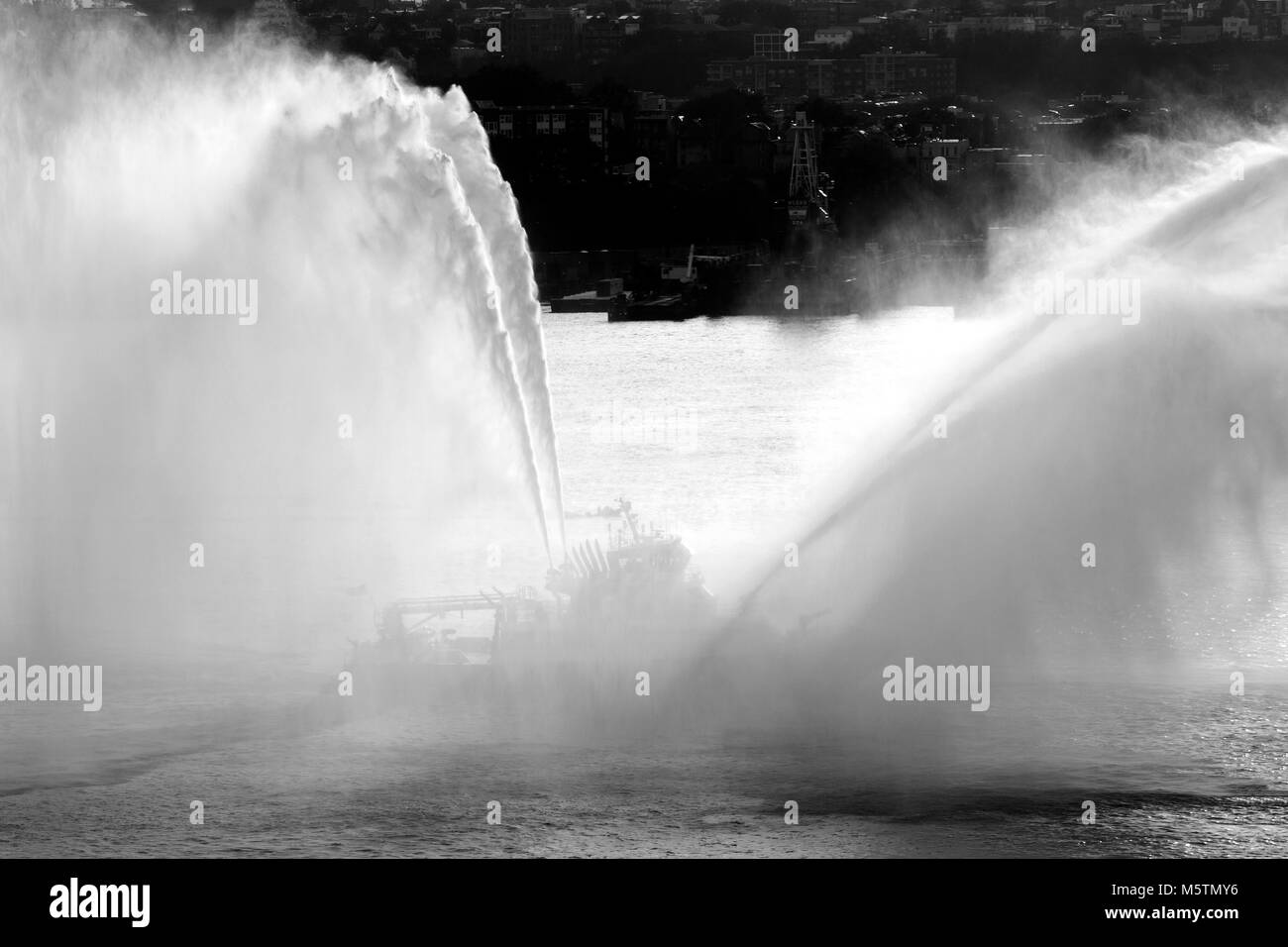 A fire boat splashing water in the river Stock Photo - Alamy