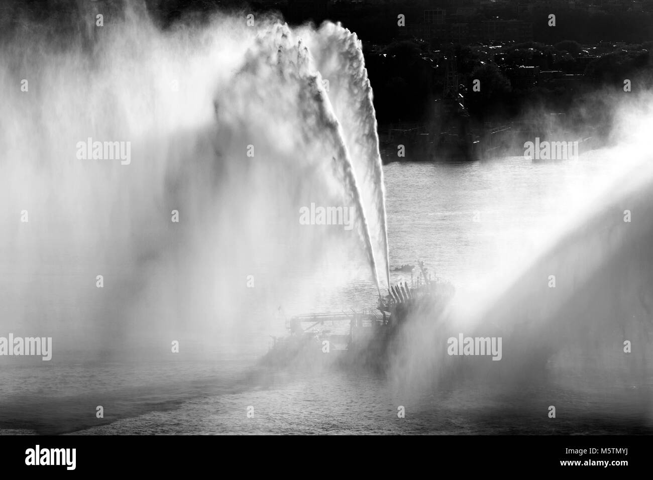 A fire boat splashing water in the river Stock Photo - Alamy