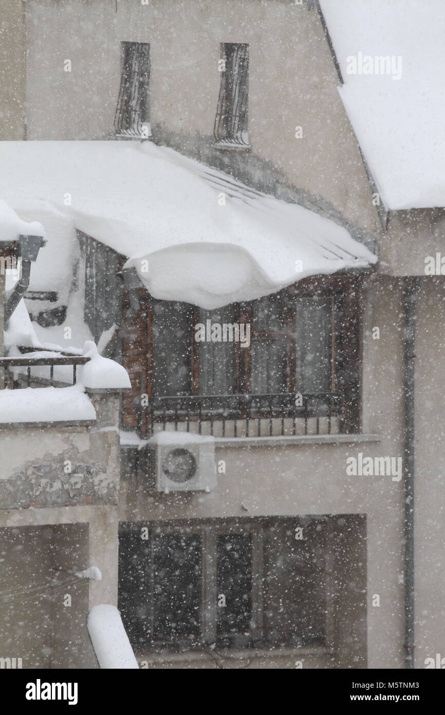 Winter. Dangerous snow falls from the roofs of the buildings. Winter ...