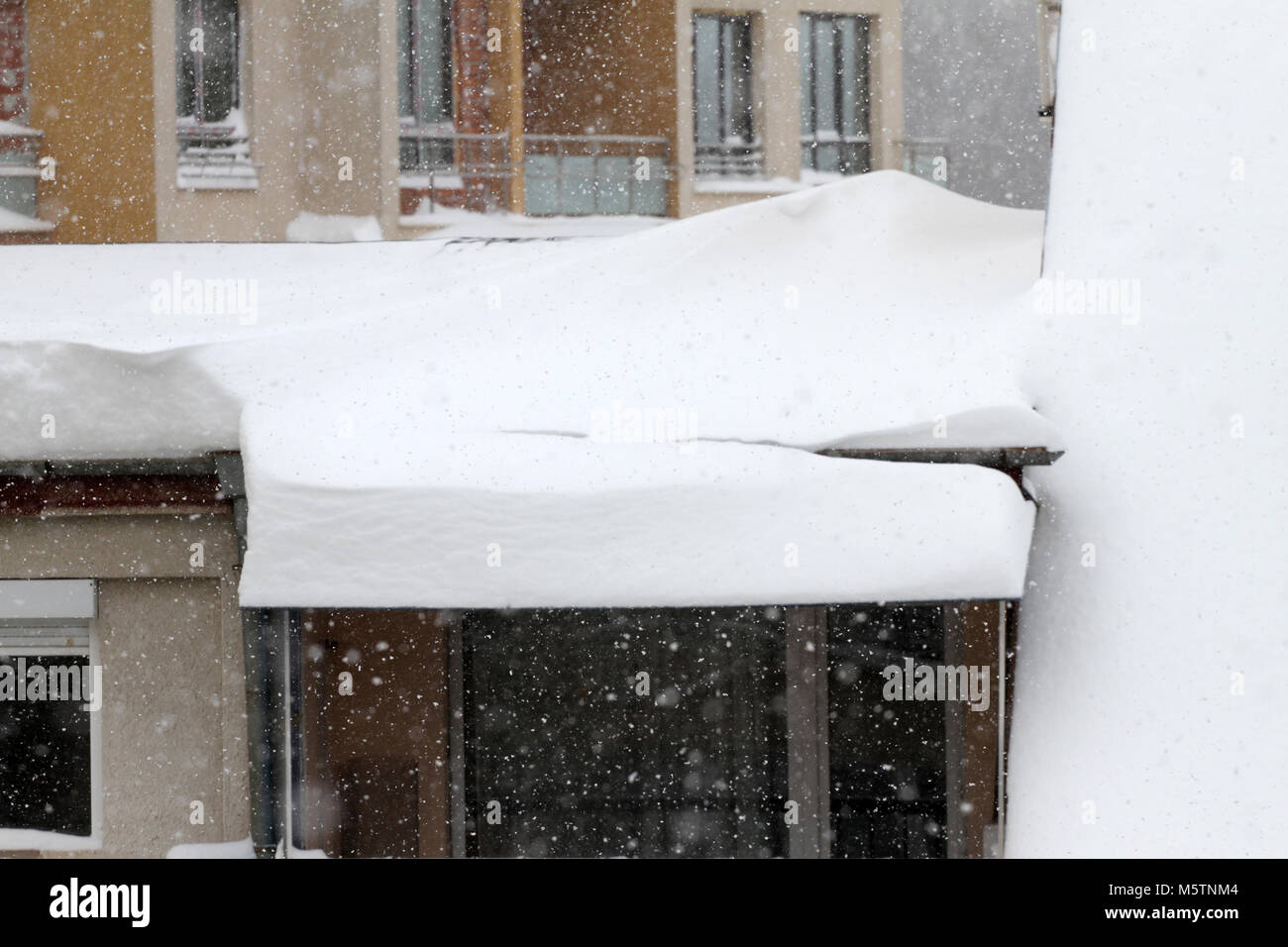 Winter. Dangerous snow falls from the roofs of the buildings. Winter ...
