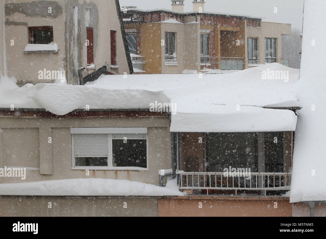 Winter. Dangerous snow falls from the roofs of the buildings. Winter ...