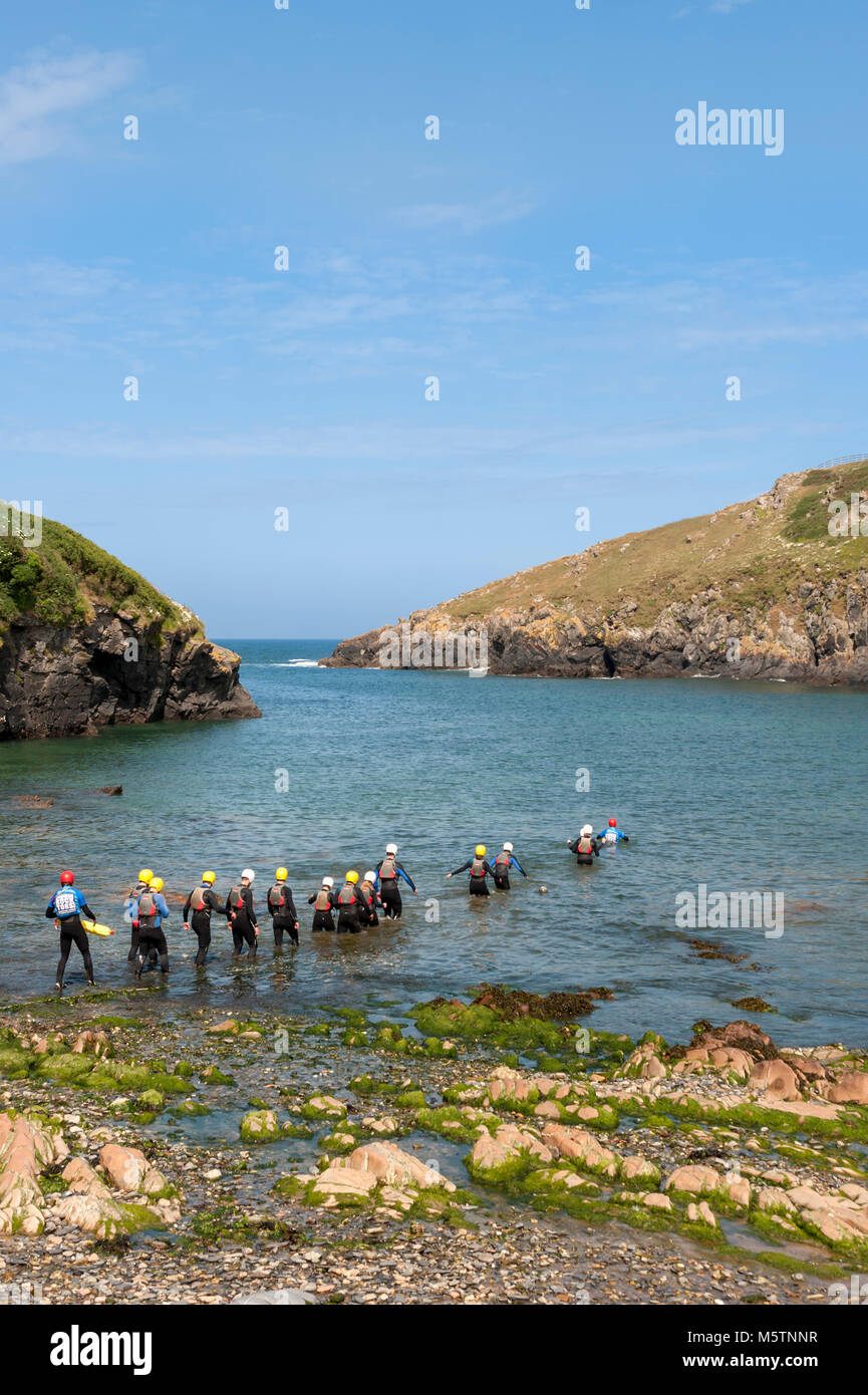 PORT QUIN, CORNWALL, UK - JUNE 13, 2009: Coasteer's entering the water ...